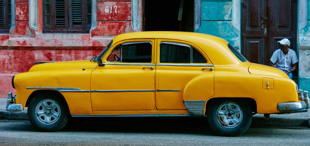 22/02/2025 – Freerange Stock – Classic yellow vintage car parked beside ...